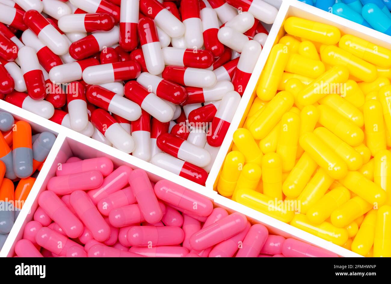 Top view multi-colored antibiotic capsule pill in tray. Antibiotic drug ...