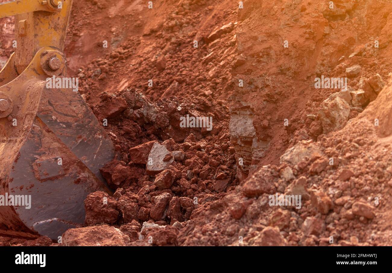 Backhoe working by digging soil at construction site. Bucket of backhoe ...