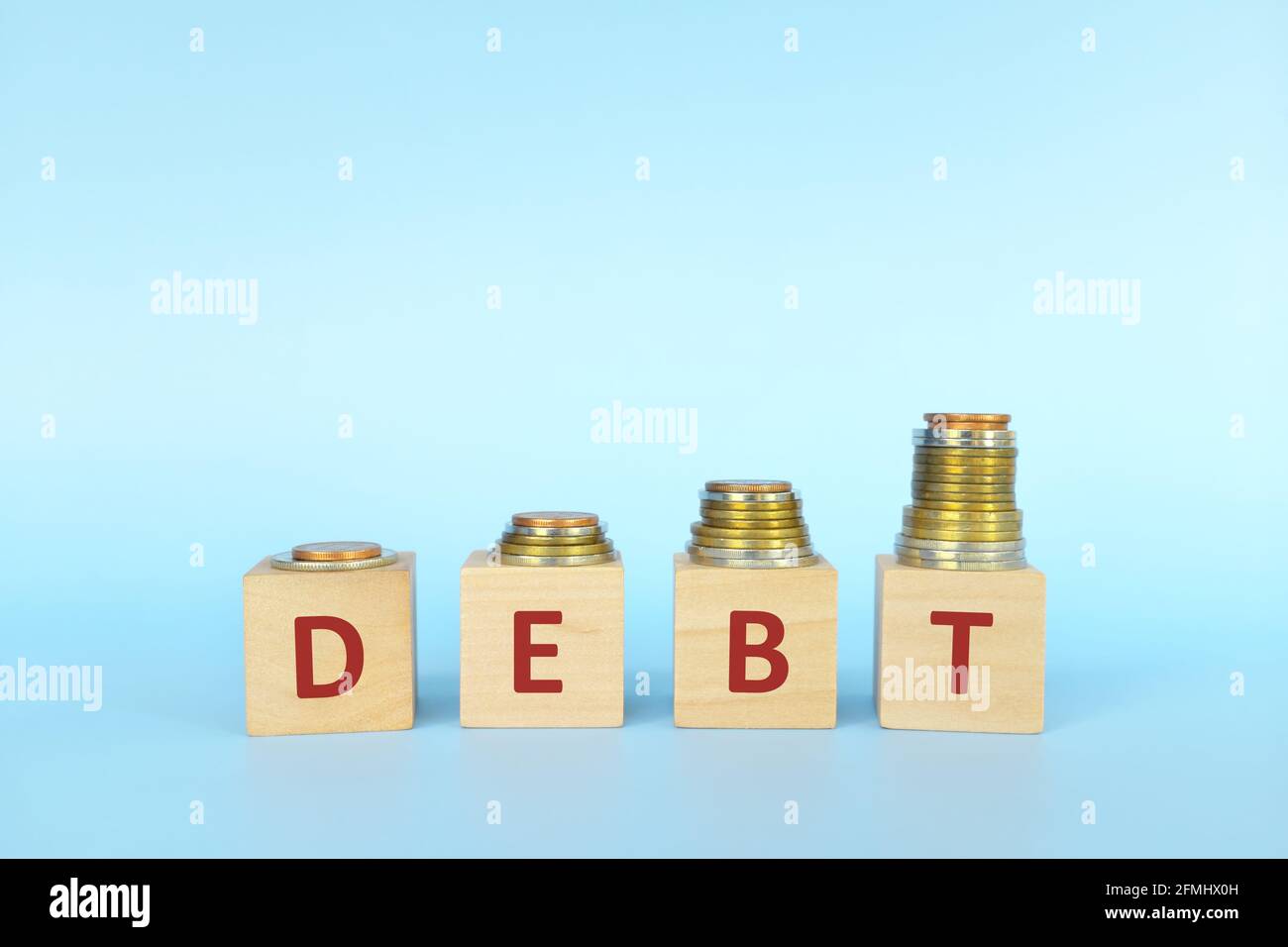 Debt increase concept. Increasing stack of coins with word debt in blue ...