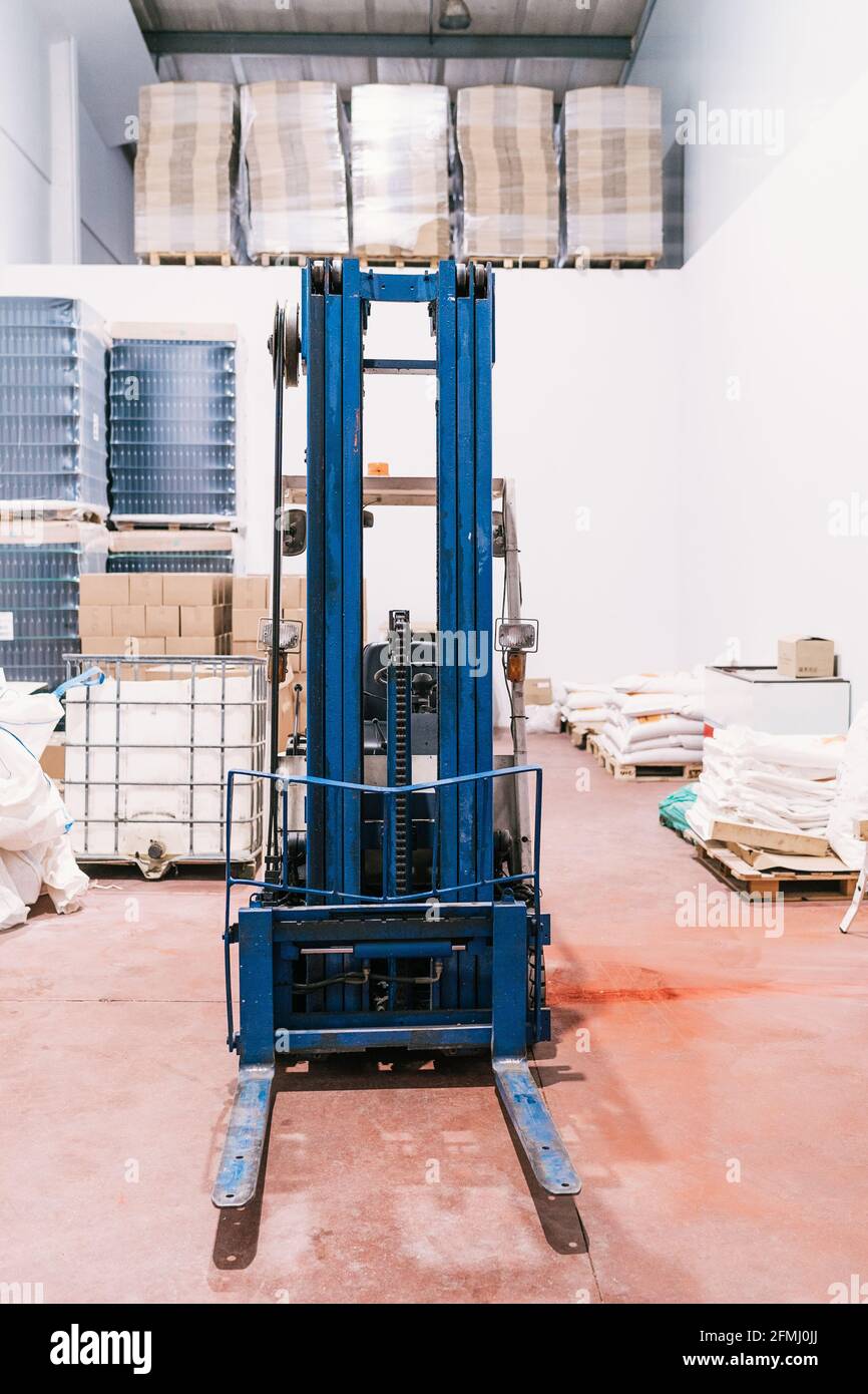 Industrial vehicle on floor against stack of cardboard boxes and ...