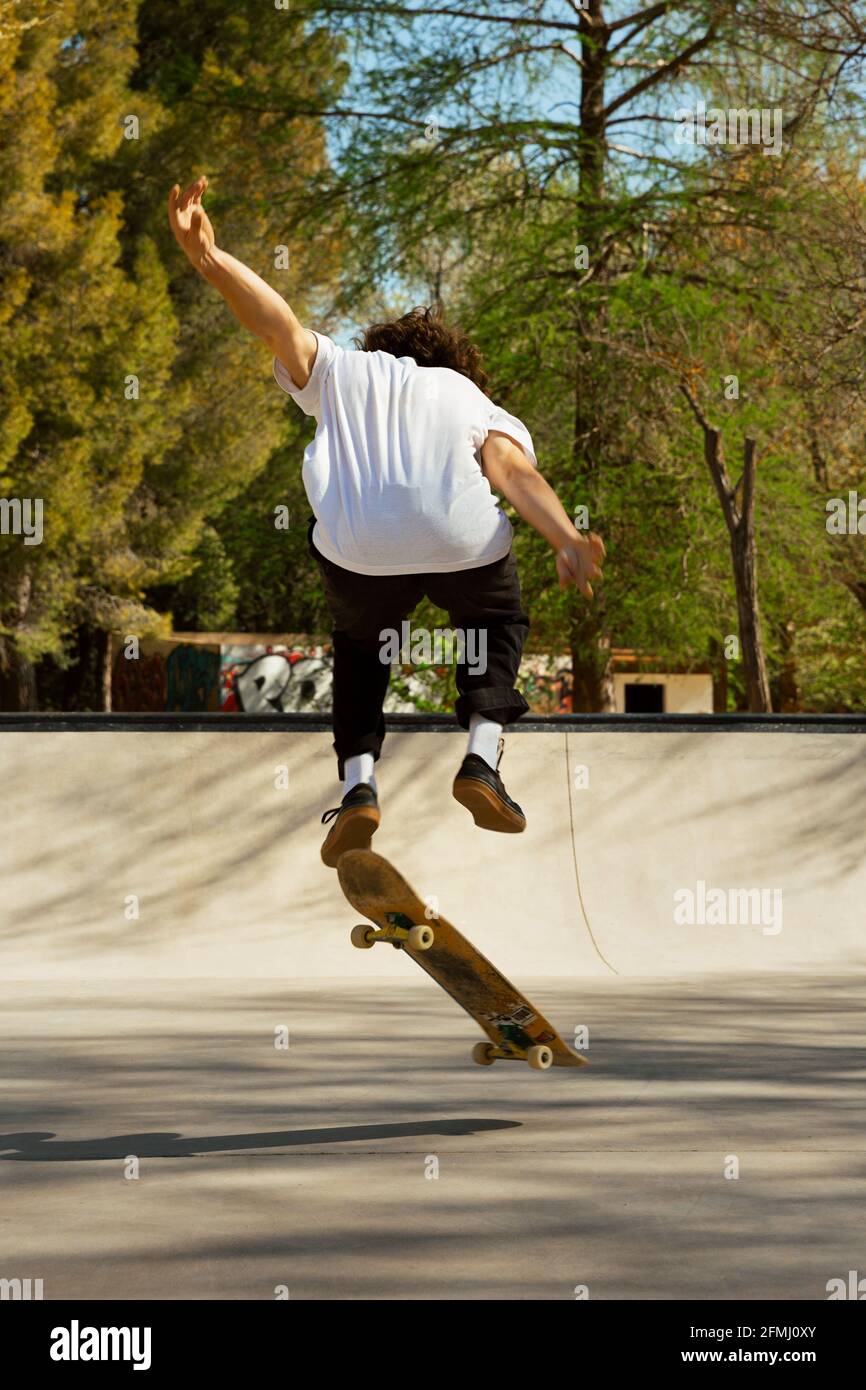 Back view of skater jumping on his board Stock Photo - Alamy