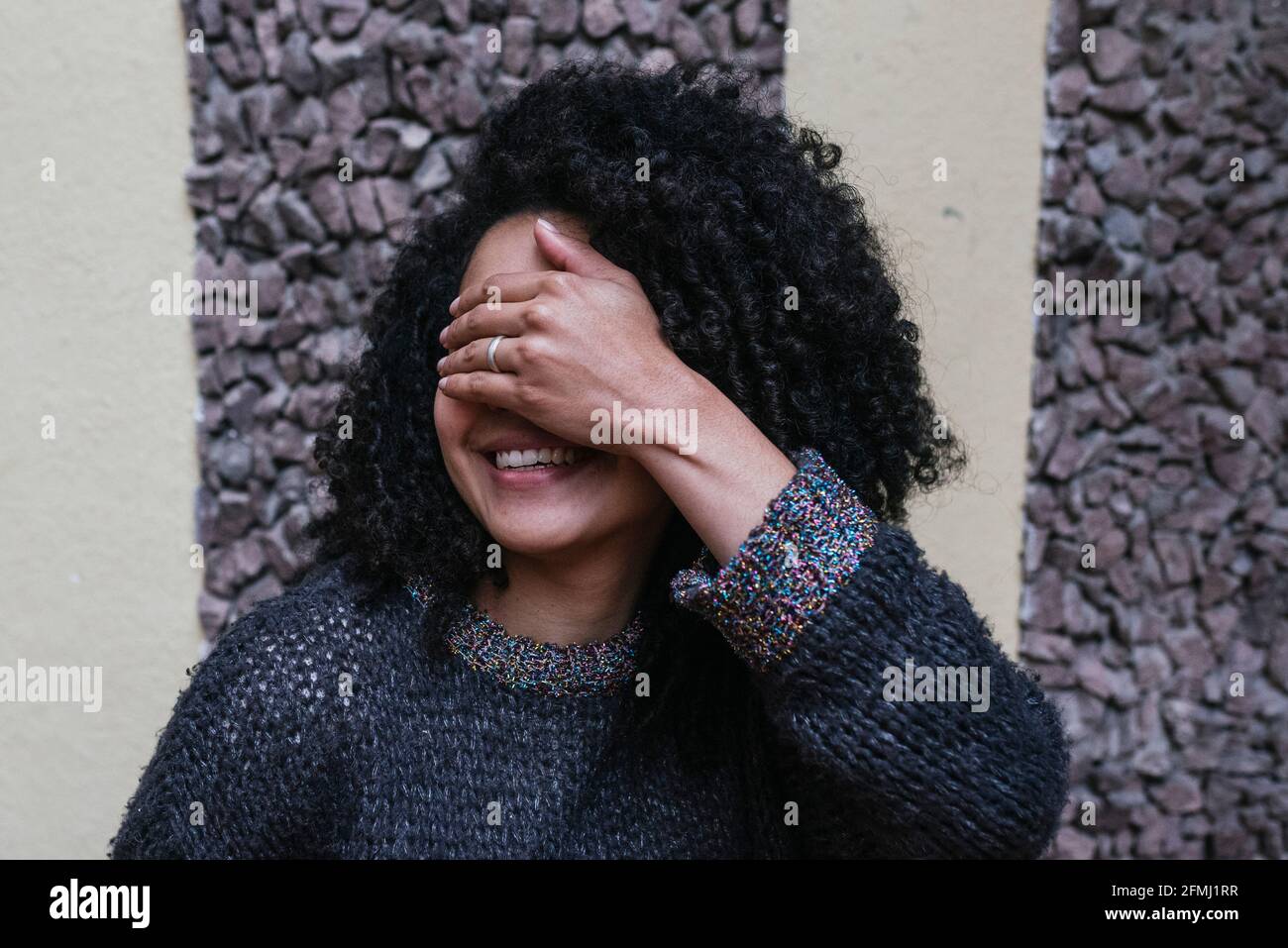 Delighted ethnic female with Afro hairstyle standing on street and ...
