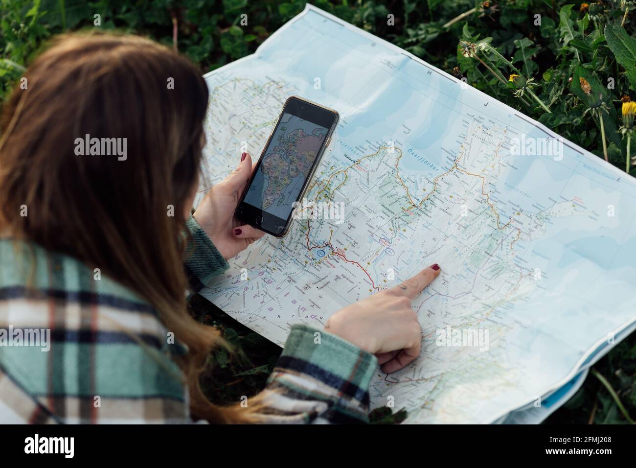 From above back view of unrecognizable female tourist with cellphone ...