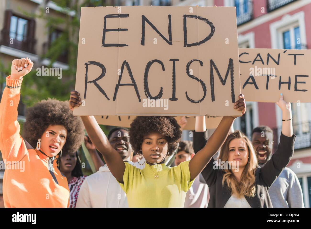 African American female activist with afro hair standing with End ...