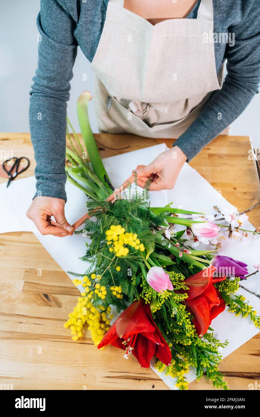 From above cropped unrecognizable female florist in casual clothes and ...