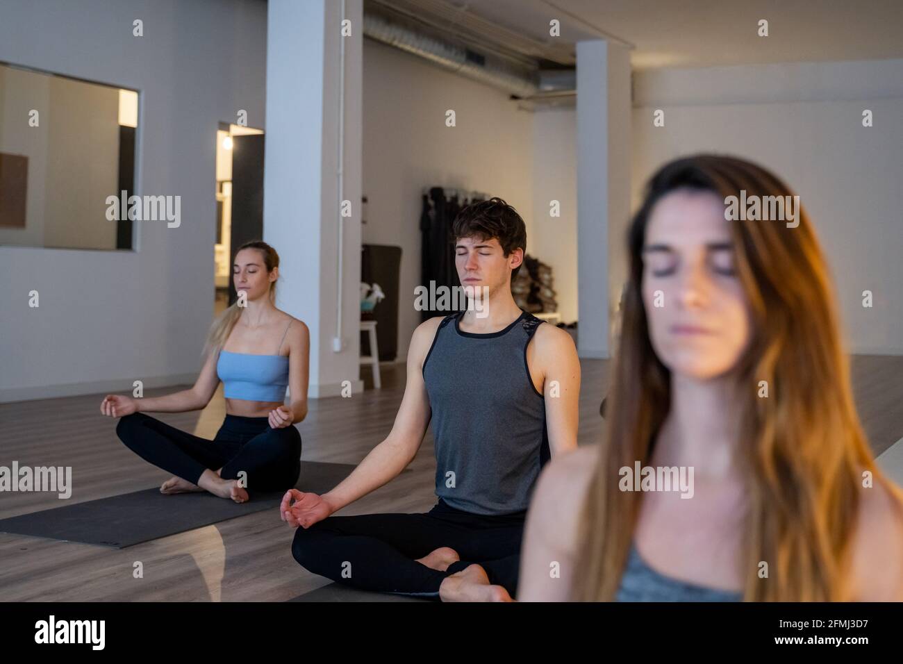 Group of diverse people sitting in Lotus pose with closed eyes and ...