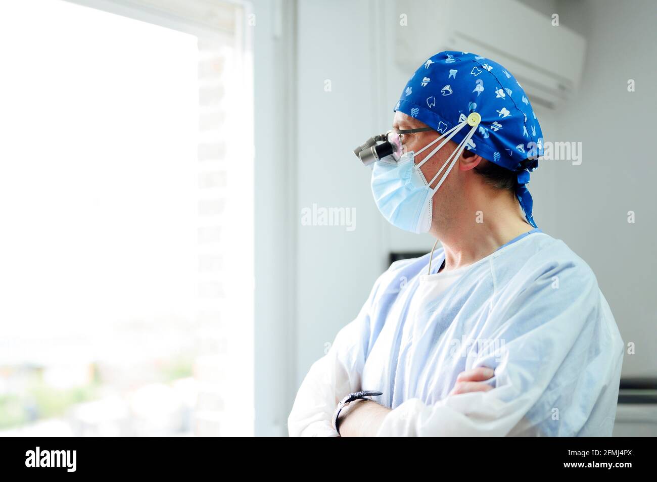 Anonymous male doctor in uniform and sterile mask looking away with ...