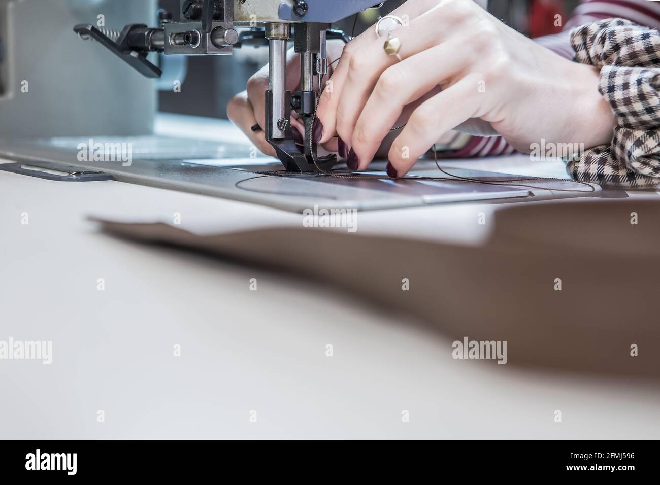 Crop female artisan using sewing machine while creating upholstery for ...