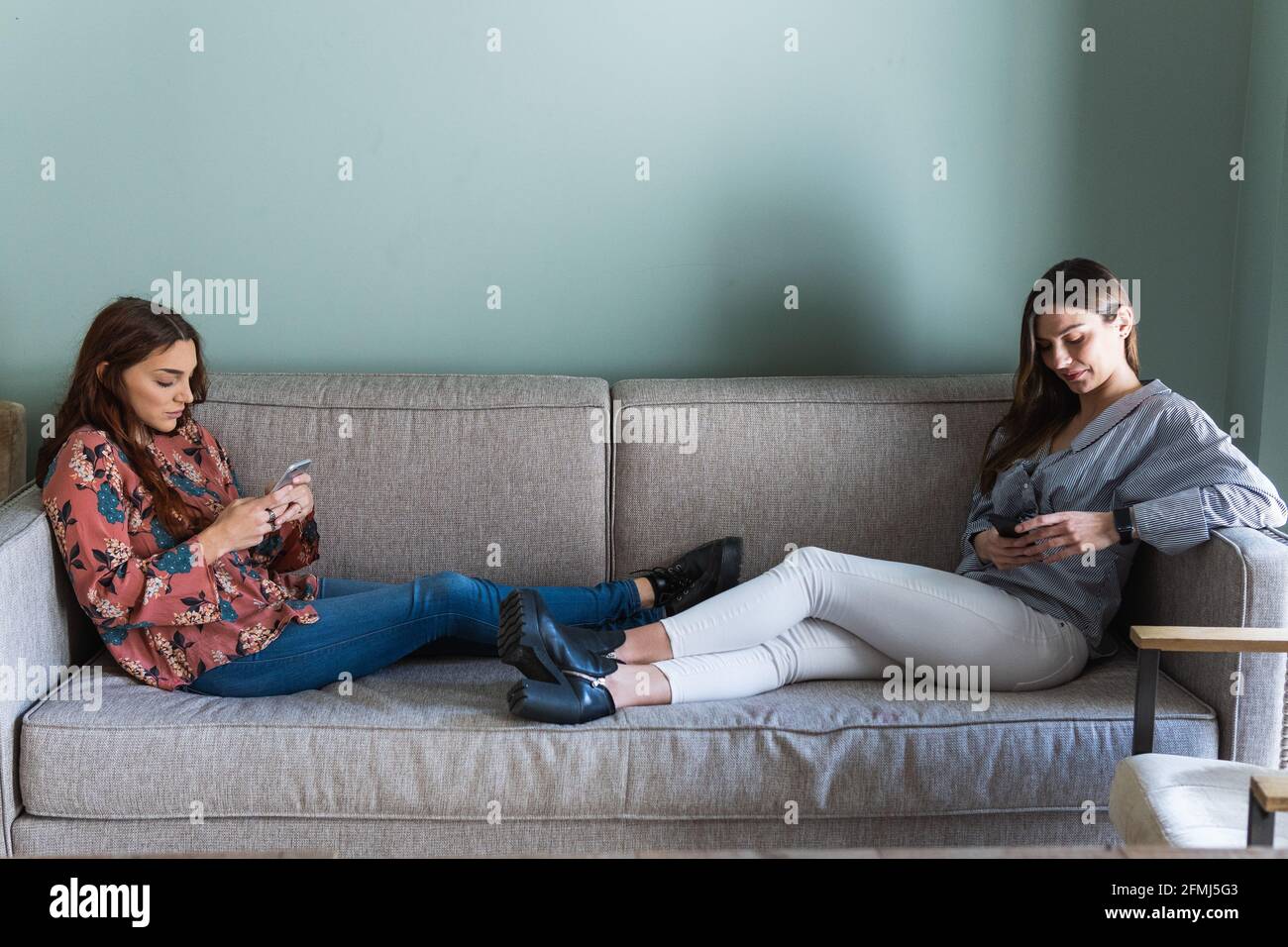 Full body side view young females in casual outfits resting on ...