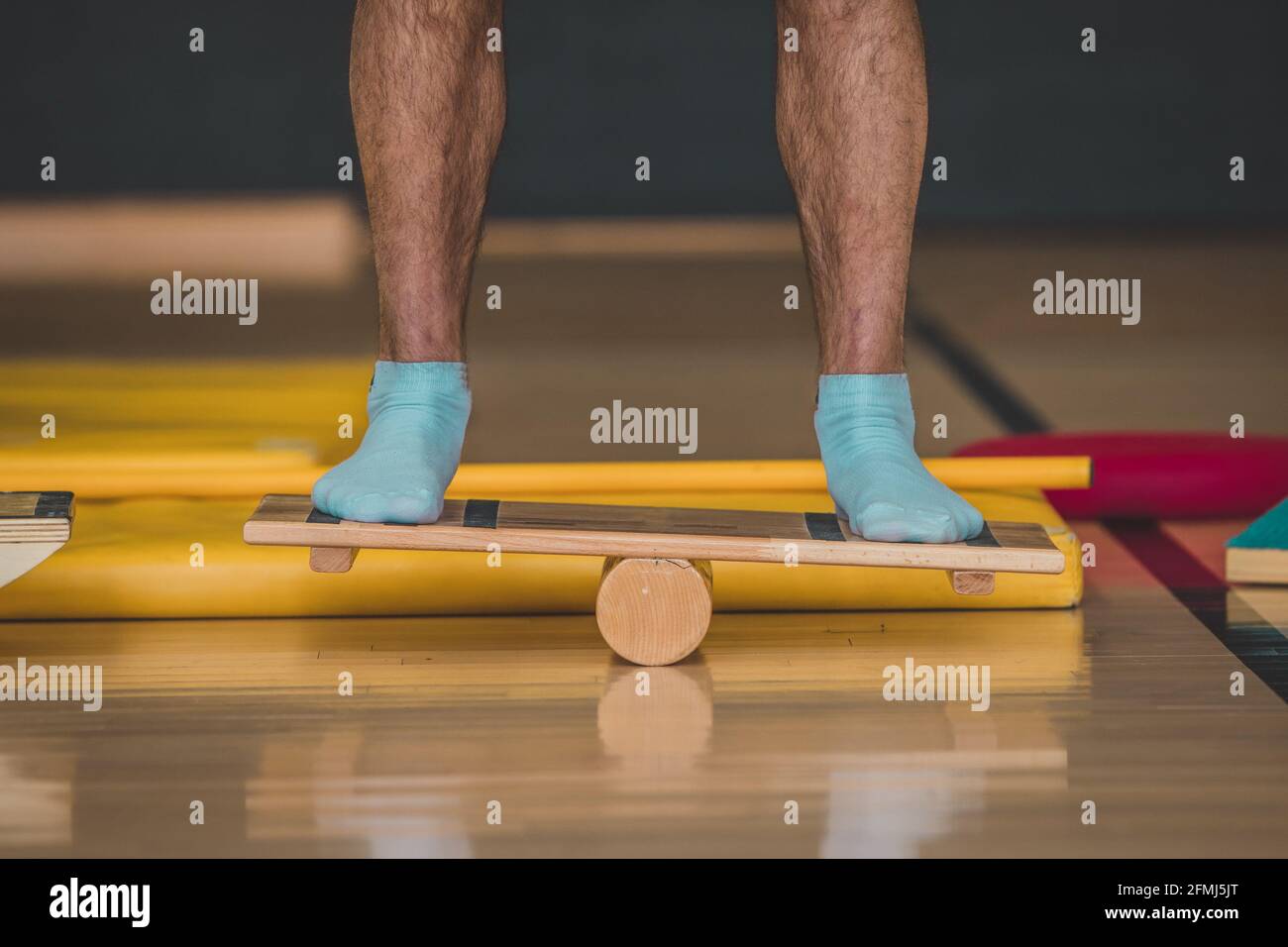 Front view of male trainer seen using a wooden balance board. Different ...