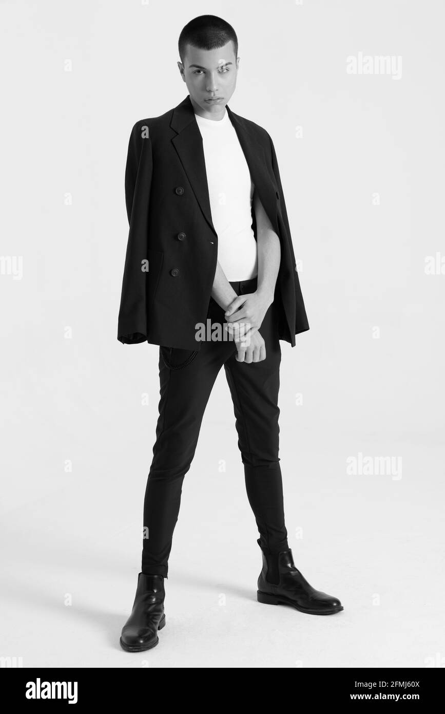 Serious male model in fashionable suit standing on white background in ...