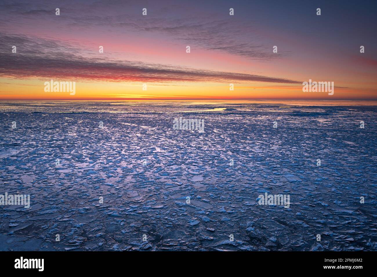 Beautiful sunset colors on the sky and clouds. Ice patterns and texture ...