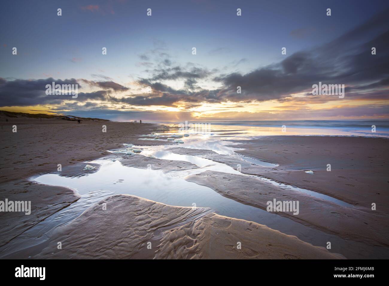 Maritime landscape at sunset with reflection of clouds in low tide ...