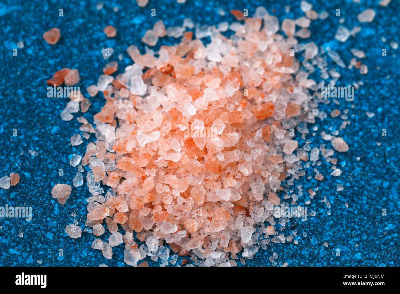 Pink coarse salt crystals on a blue table. Himalaya salt. Background ...