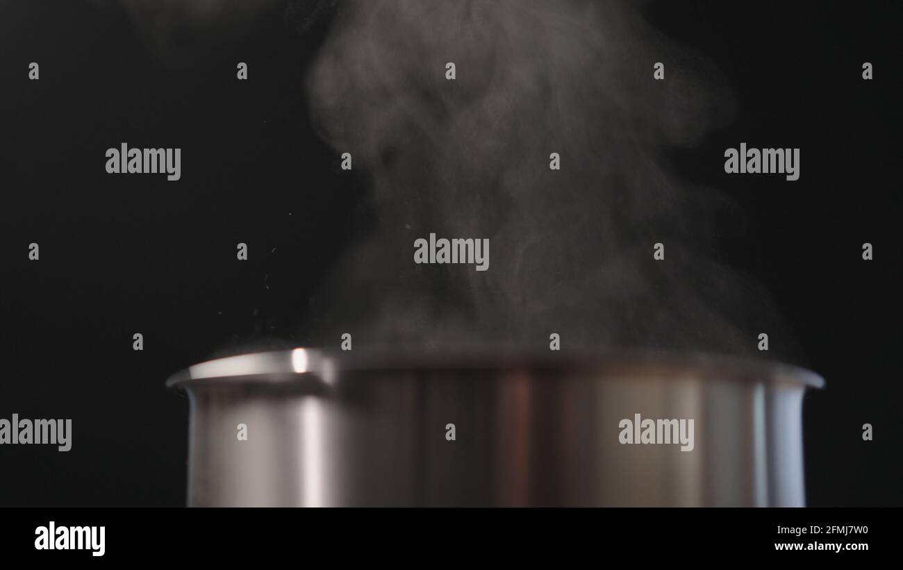 Steam rising from pot over black background, wide photo Stock Photo - Alamy