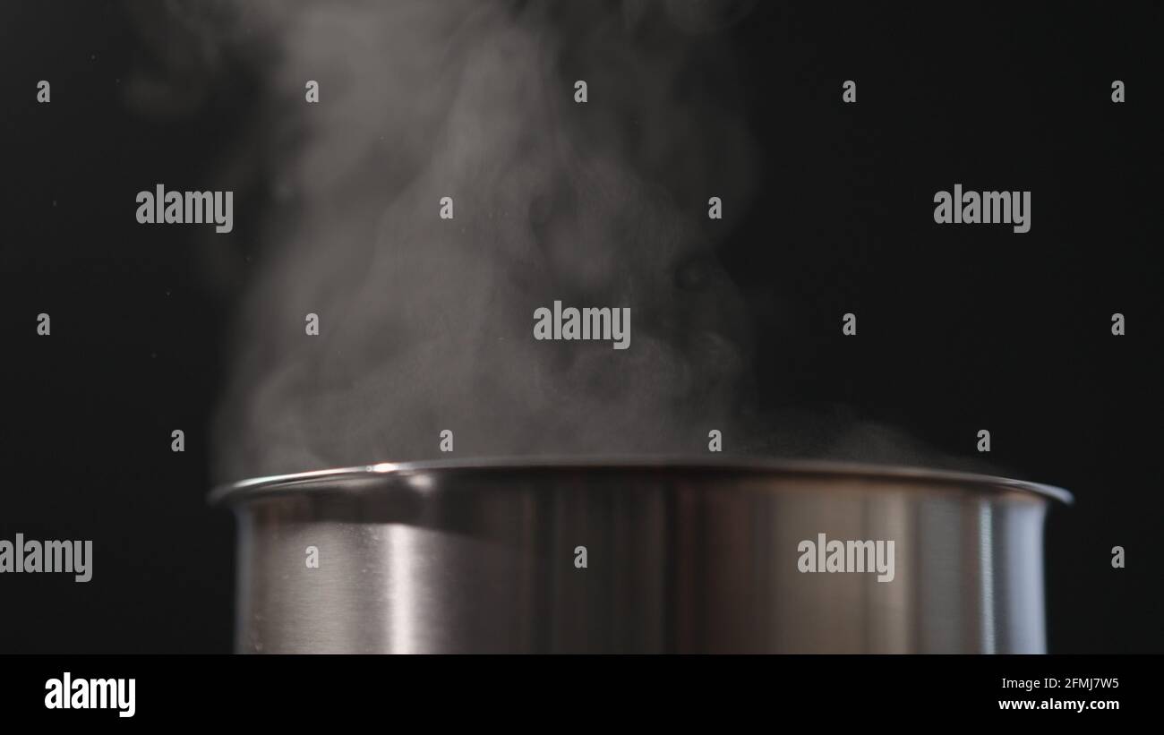Steam rising from pot over black background, wide photo Stock Photo - Alamy