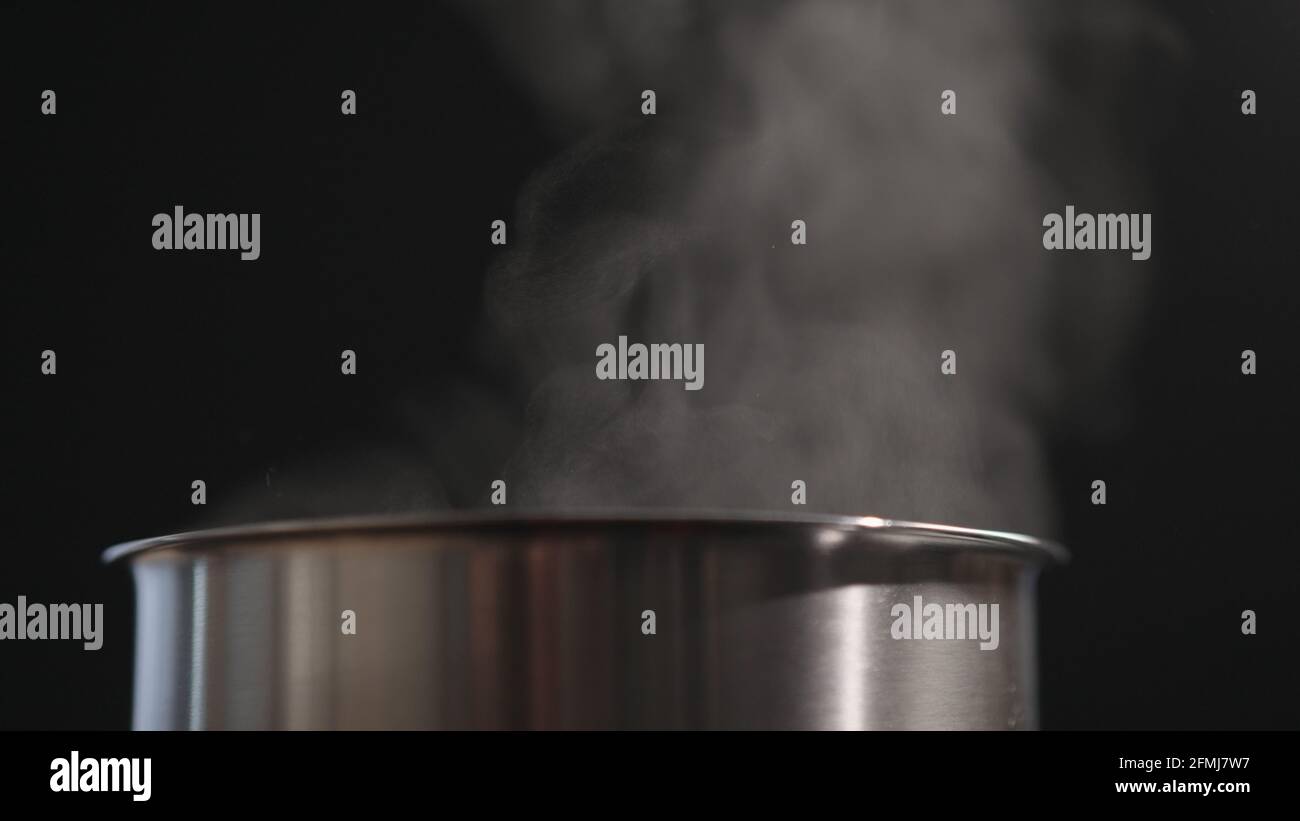 Steam rising from pot over black background, wide photo Stock Photo - Alamy