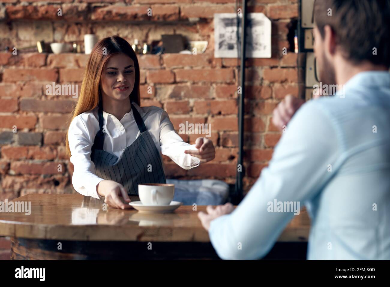 woman waiter brings coffee to a cafe client Stock Photo - Alamy