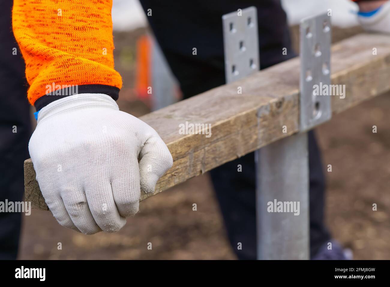 the builder twists the foundation made of screw piles. Lightweight and ...