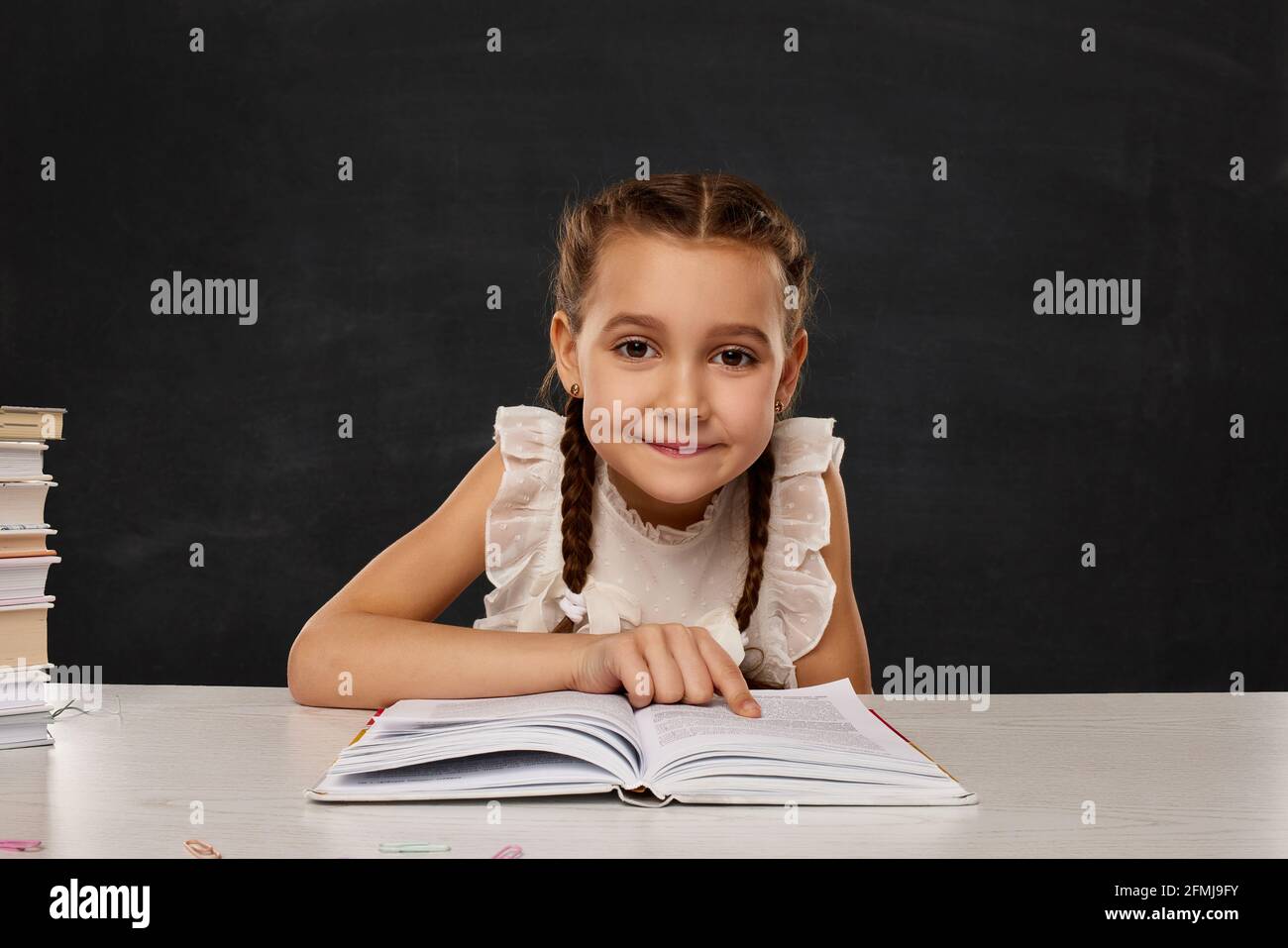 little child girl reading a book in the classroom Stock Photo - Alamy