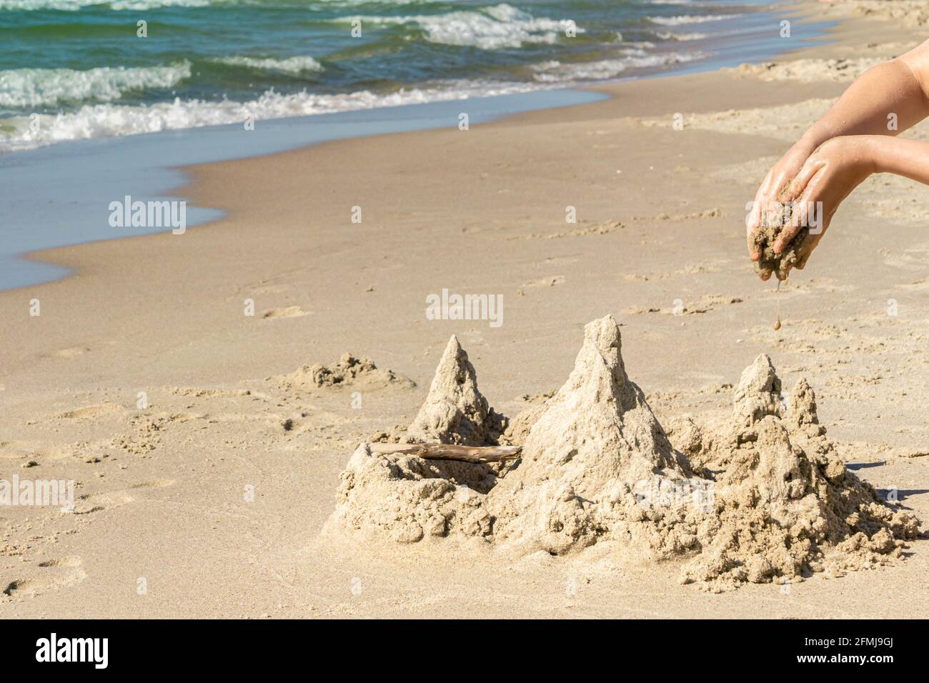 Hands making sandcastle at sea beach. Sand castle on seashore sunny day ...