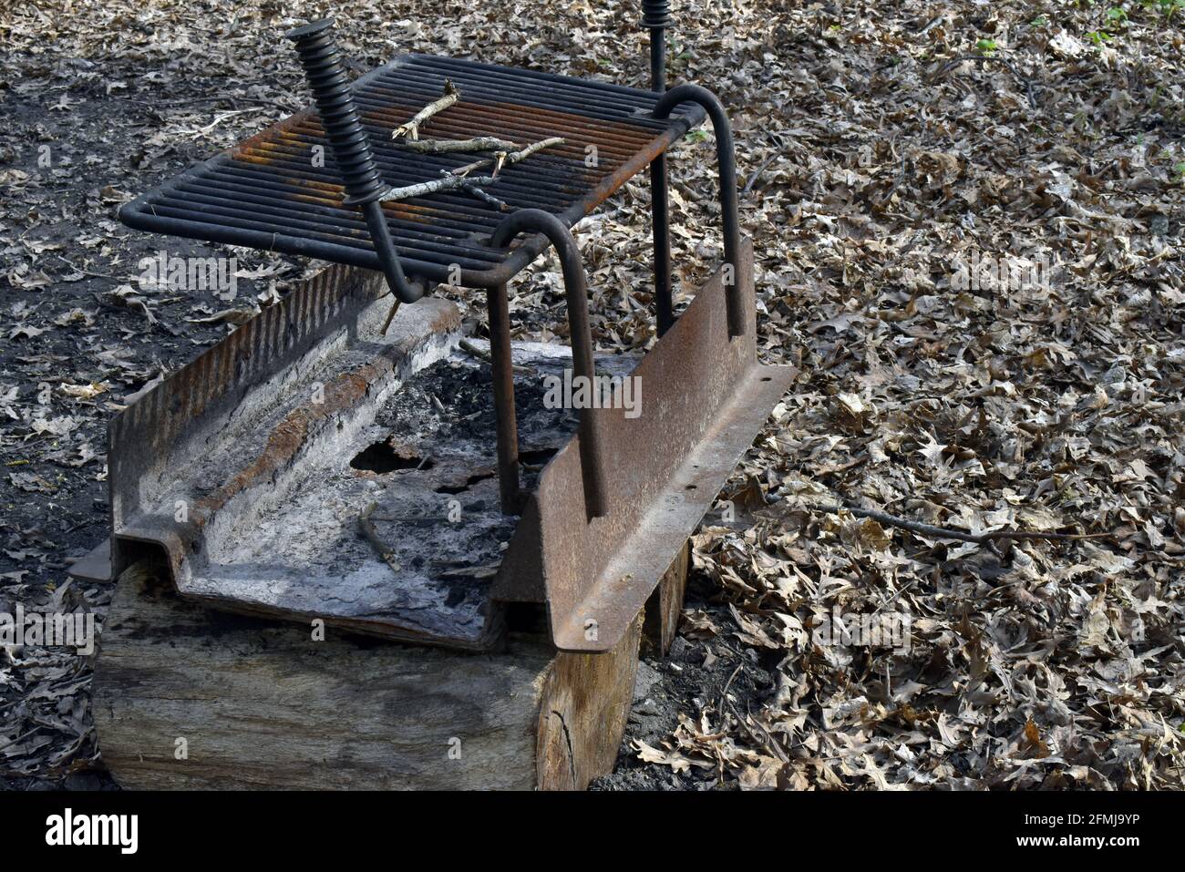 Barbeque brazier isolated in the park with dry leaves on the ground ...
