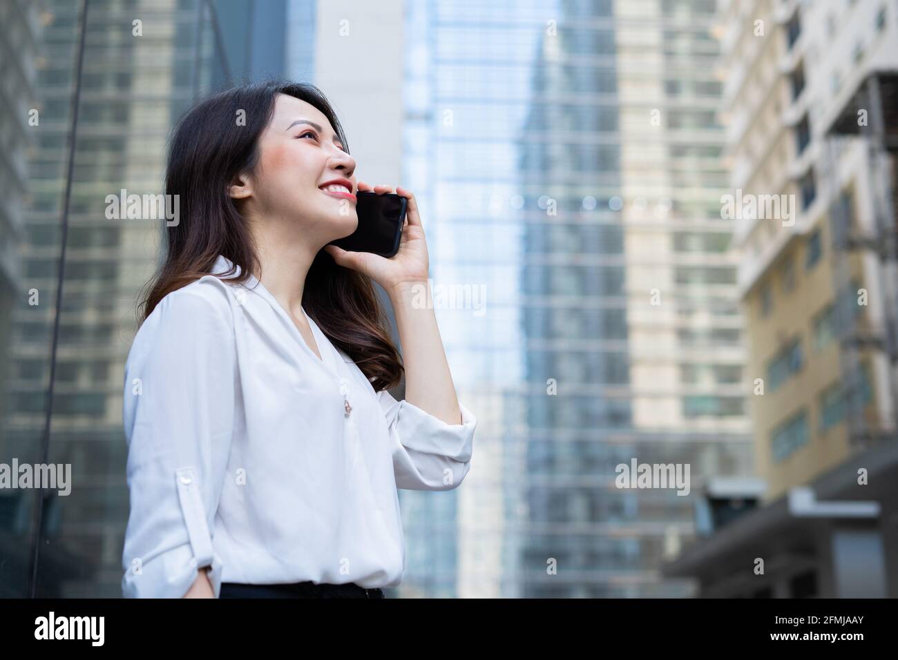 Young Asian woman calling to her friend Stock Photo - Alamy