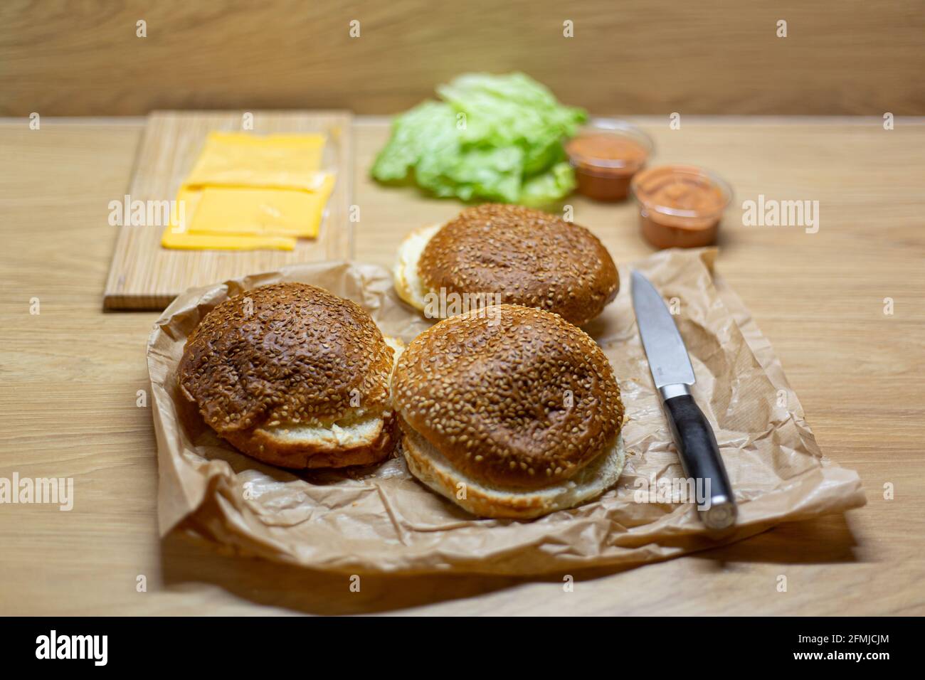 Burger bread, lettuce and cheese on the table. Process of cooking self ...
