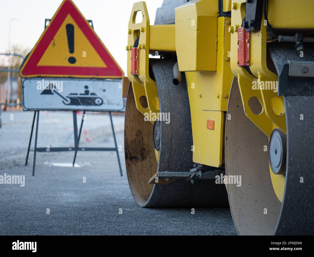 Road Sign showing Work in Progress and Big Machine for Asphalt ...
