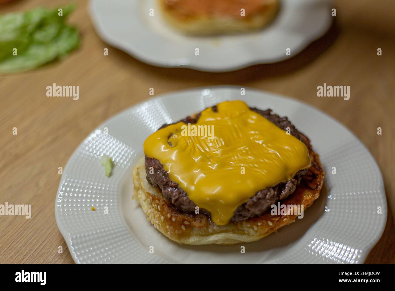 Process of cooking self made burgers at home. Cheesy burger on a white ...