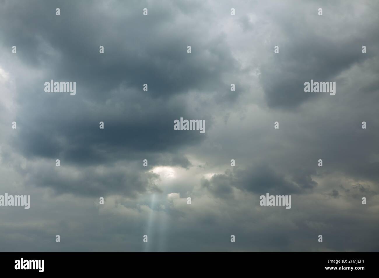Sun ray shining from gray clouds Stock Photo - Alamy