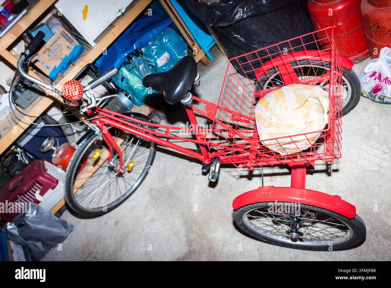 High angle shot of a red three-wheeled bicycle in the garage Stock ...