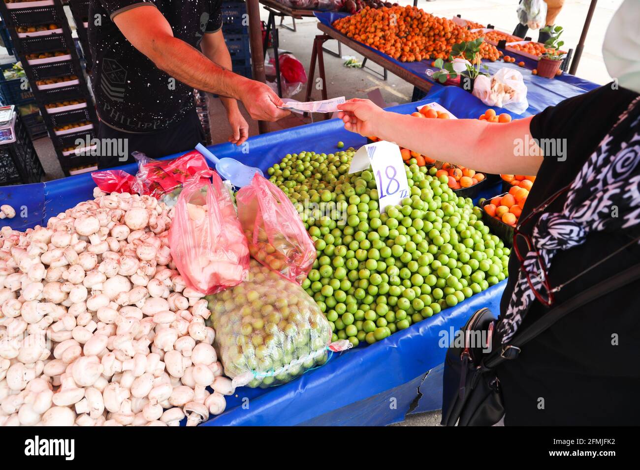 Woman buying fresh organic green vegetables at the village bazaar ...
