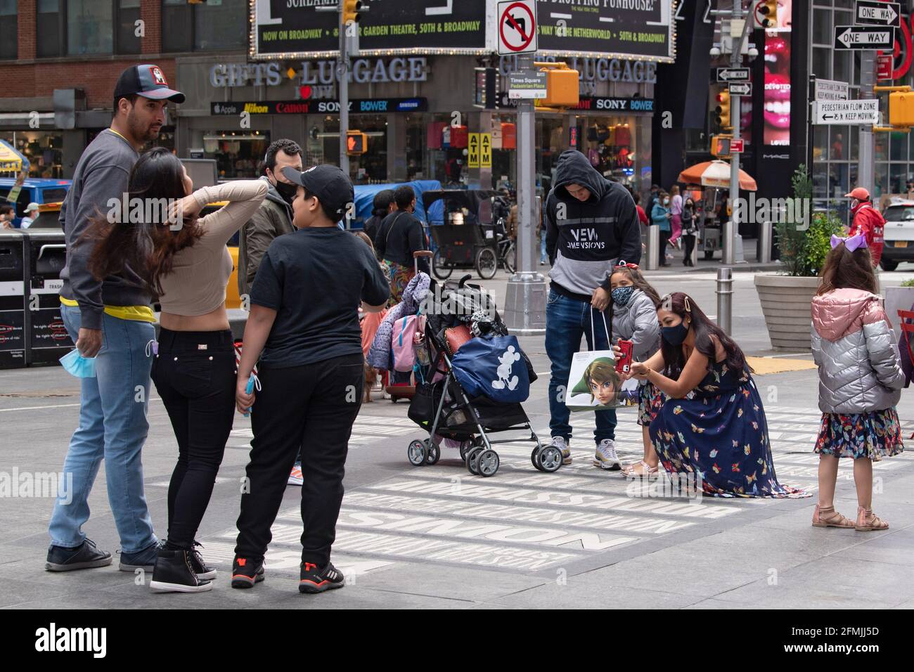 Tourists pose for pictures in Times Square, New York City.This Sunday ...