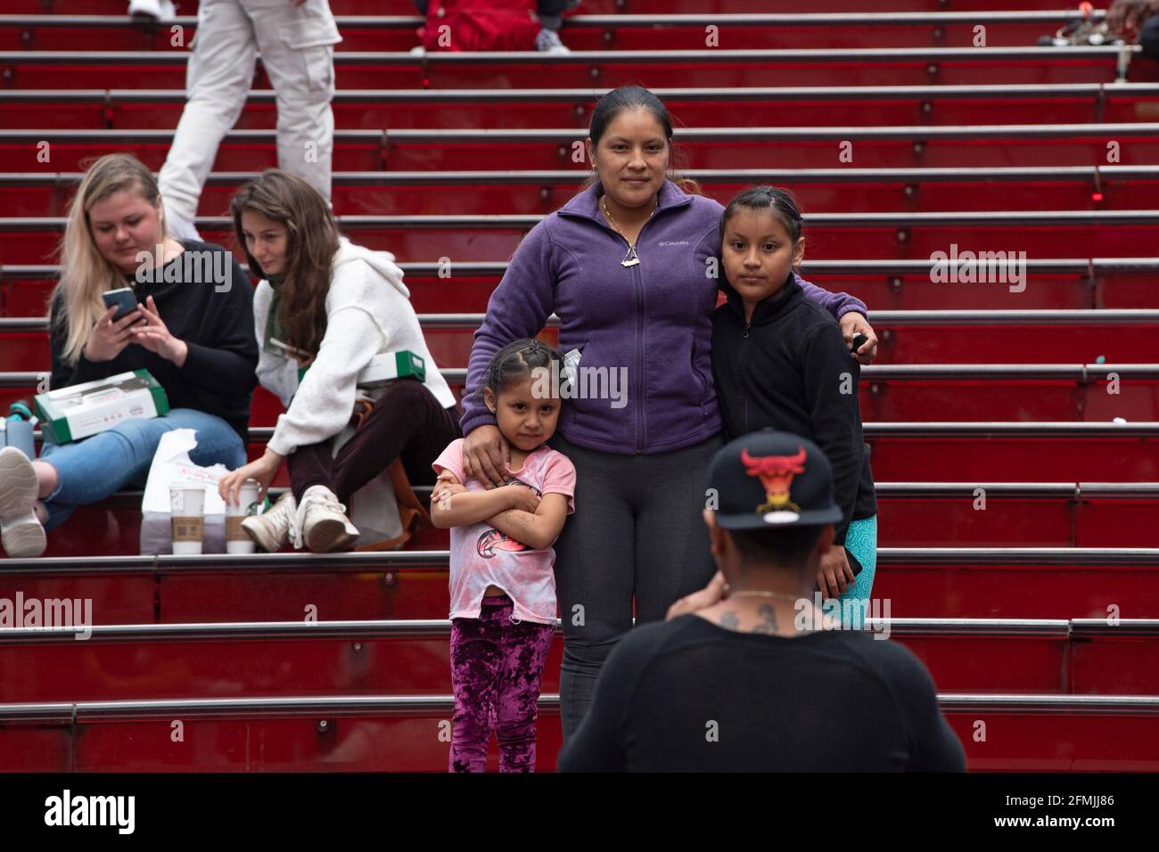 A woman and kids pose for pictures in Times Square, New York City.This ...