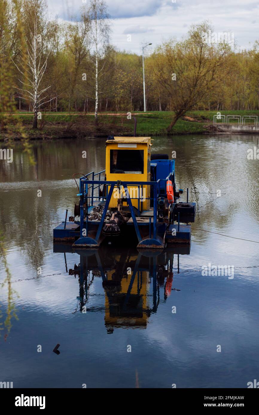 River cleaning boat collects garbage on water surface of river. Trash ...