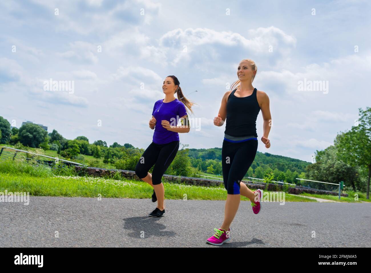 Urban sports - two women or female friends running together for better ...