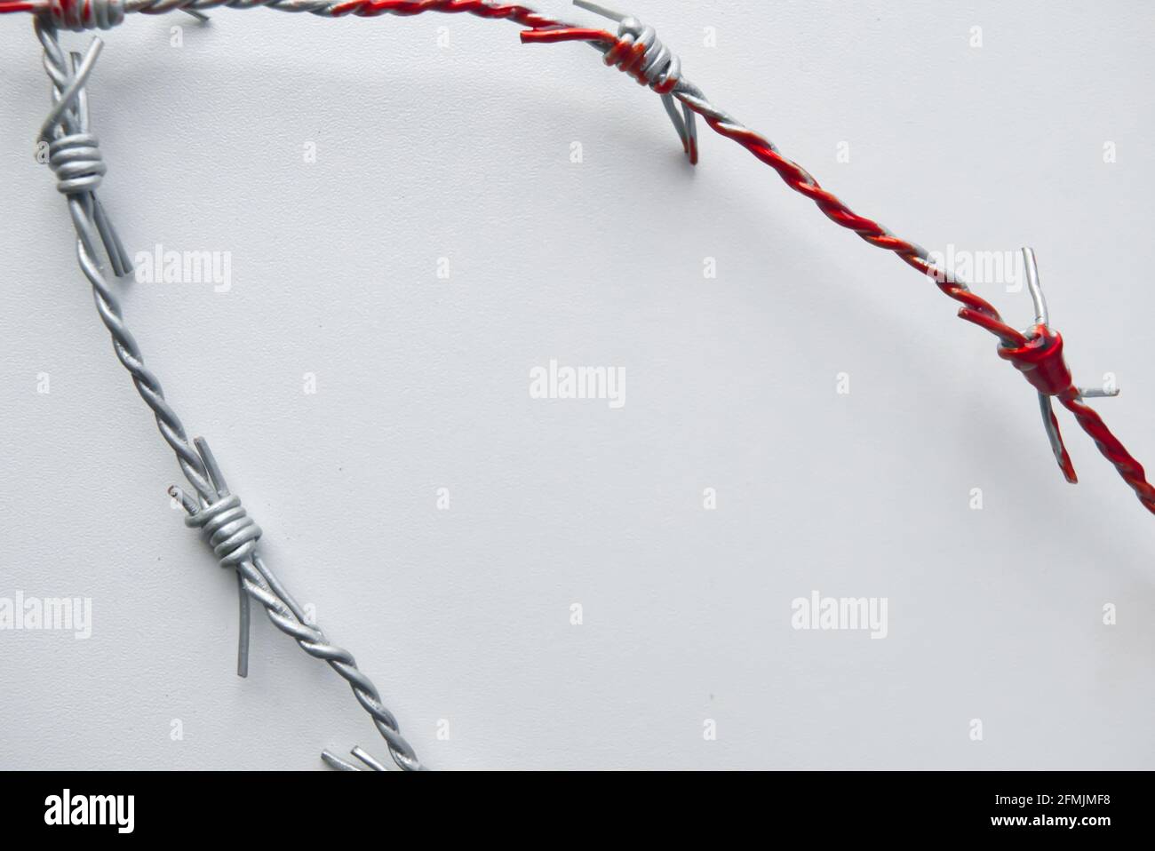 two strands of barbed wire on a white background one is bloodstained ...