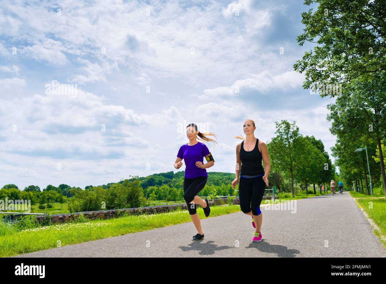 Urban sports - two women or female friends running together for better ...