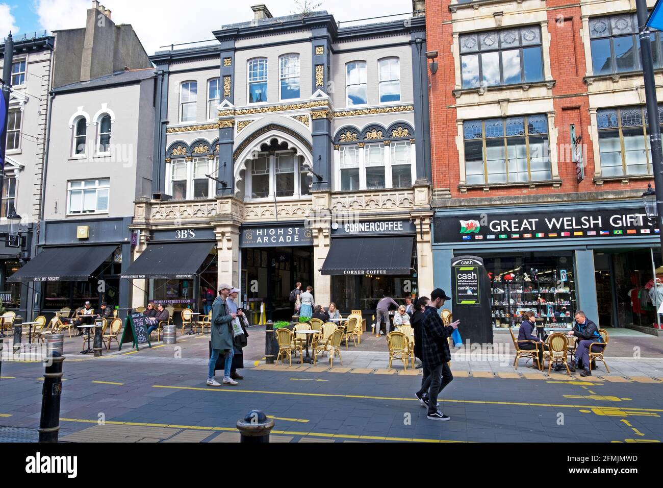 Exterior view of people walking past restaurants and High Street Arcade ...