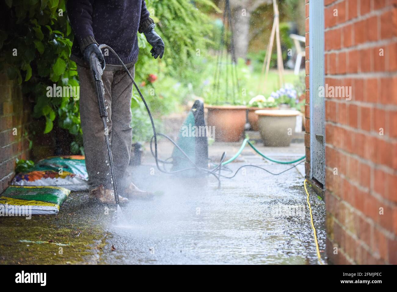 Cleaning patio paving with a high pressure washer the man is using the ...