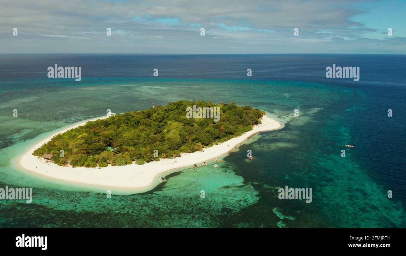 Small tropical island on an atoll with beautiful sandy beach surrounded ...