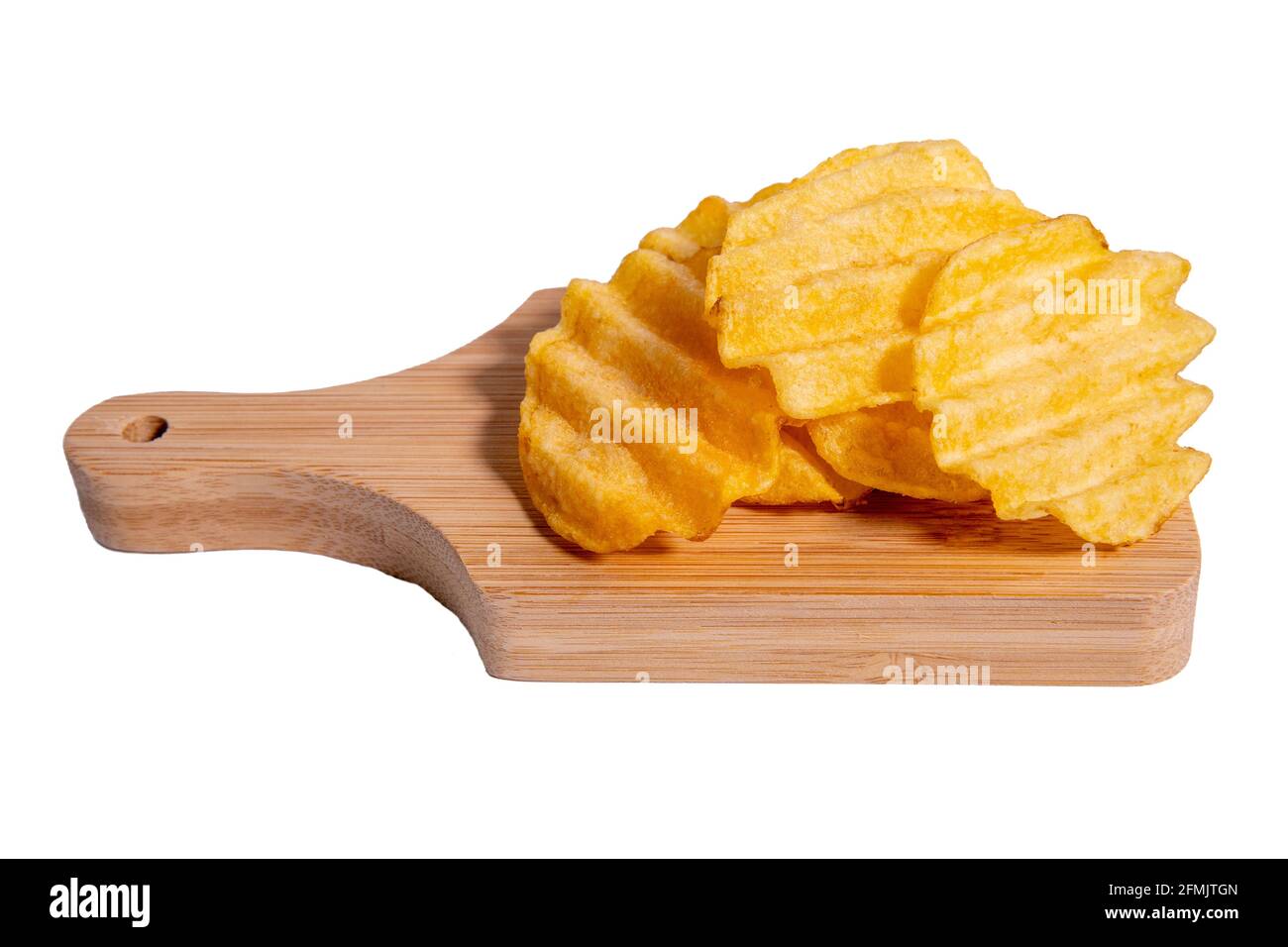 Pile of potato chips fluted on a wooden board close-up white background ...
