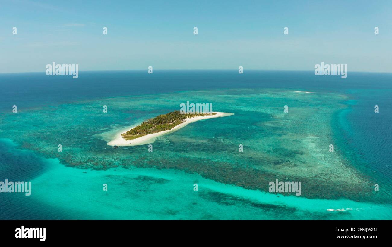 Small tropical island in the blue sea with a coral reef and the beach ...