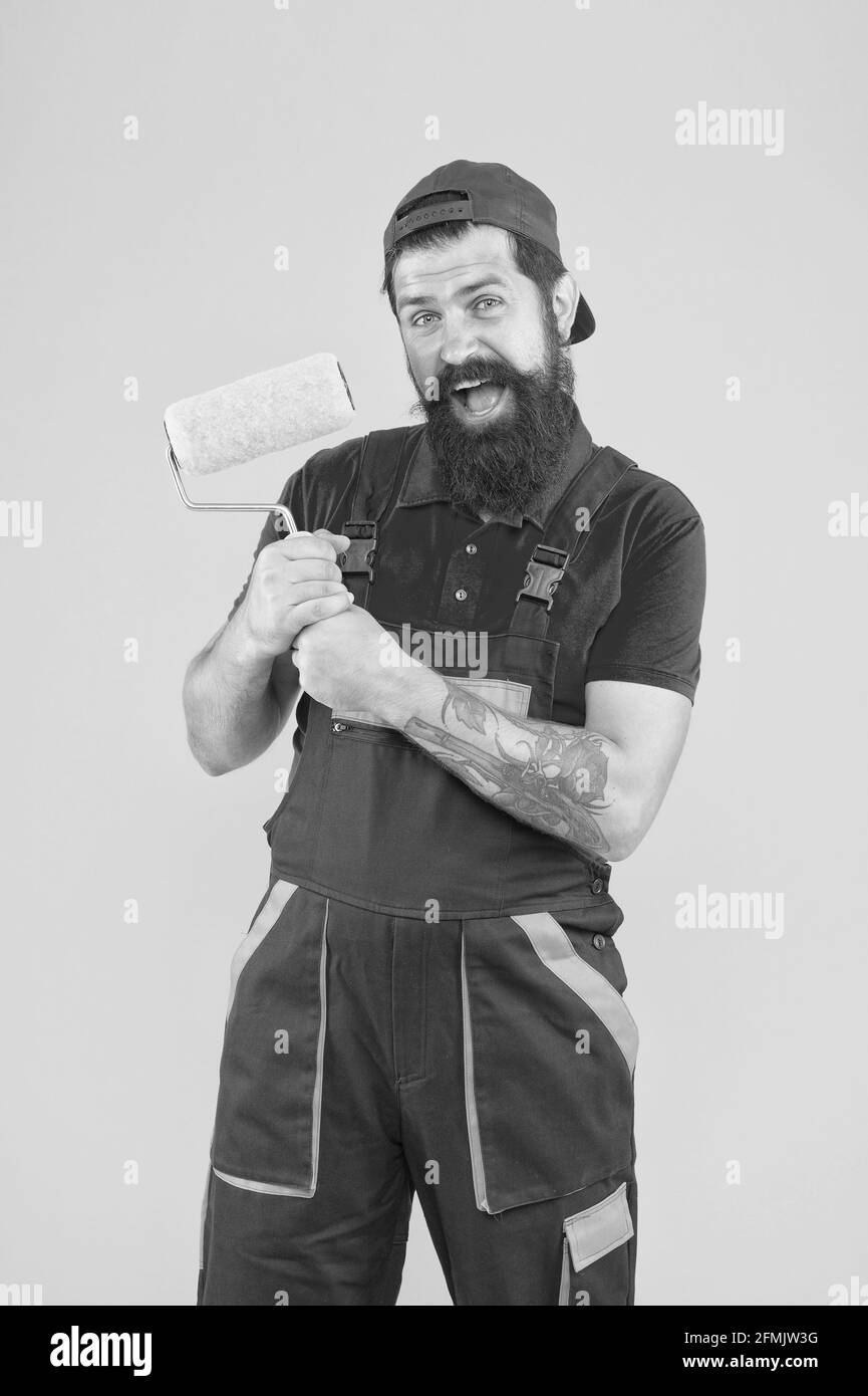 happy bearded man painter worker in boiler suit uniform using paint ...