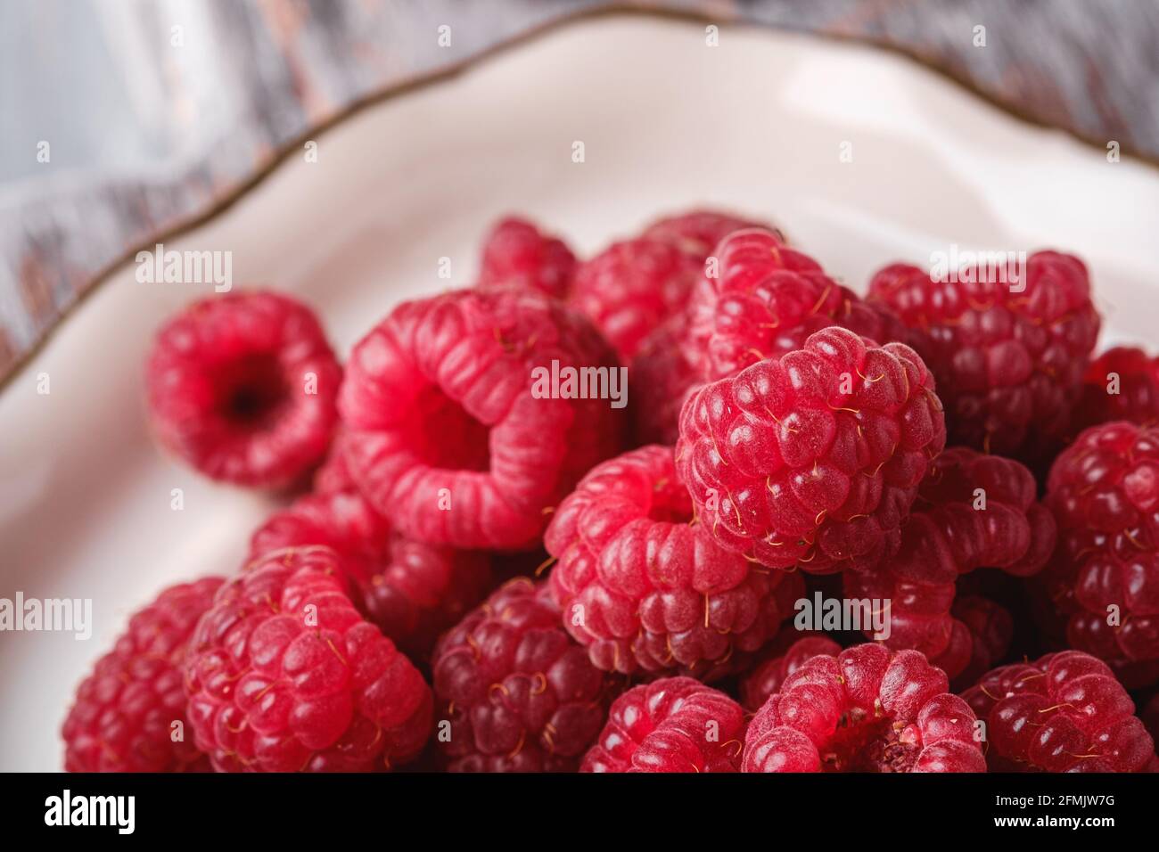 Raspberry fruits in white plate, healthy pile of summer berries, angle ...