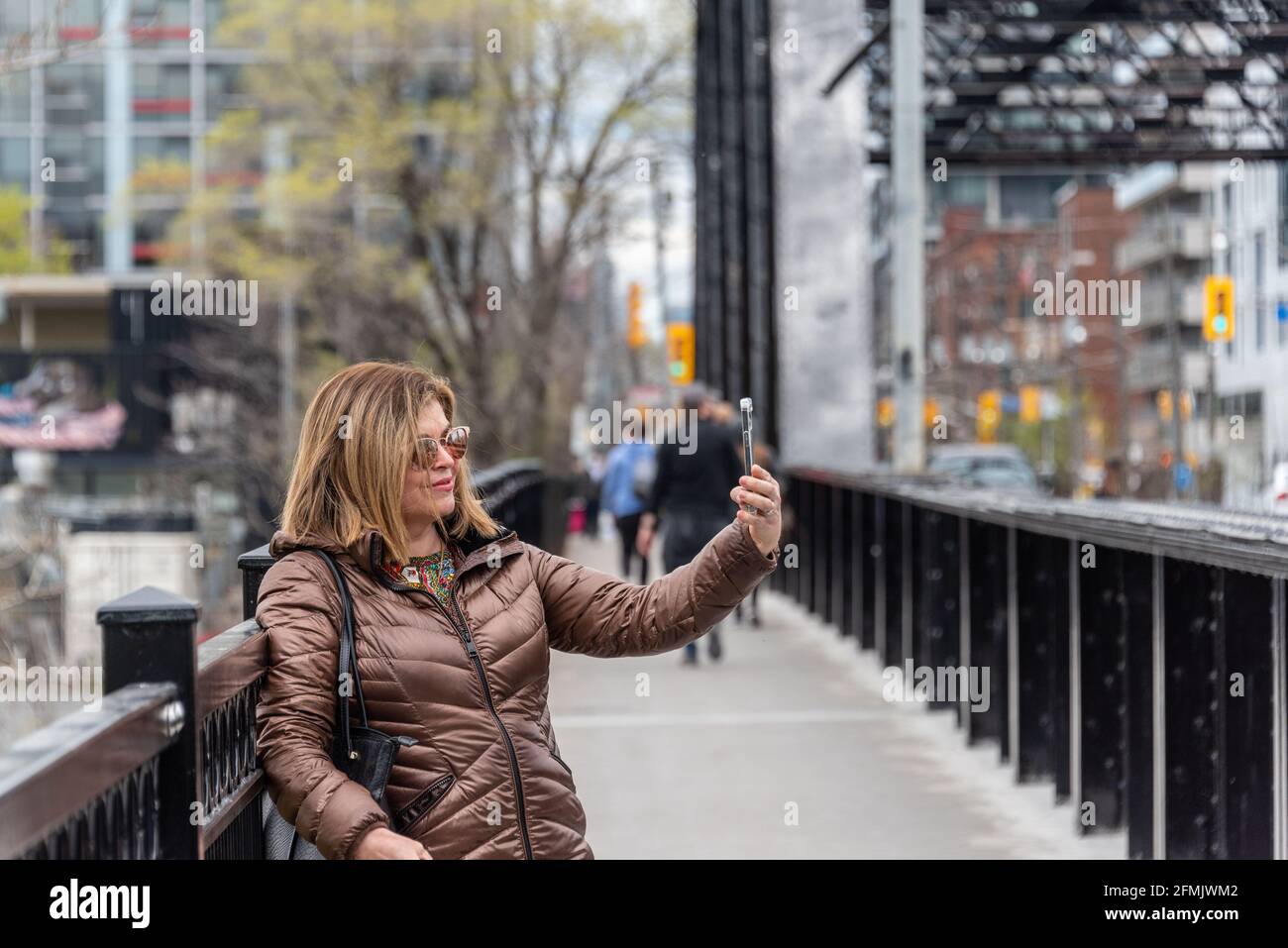 One Latin American woman taking a selfie in the Sir Isaac Brock Bridge ...