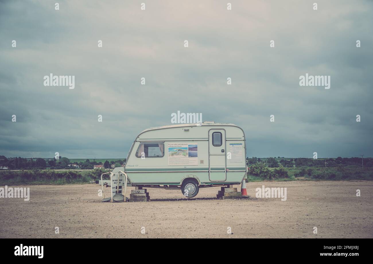 abandoned caravan in the middle of an open empty space Stock Photo - Alamy