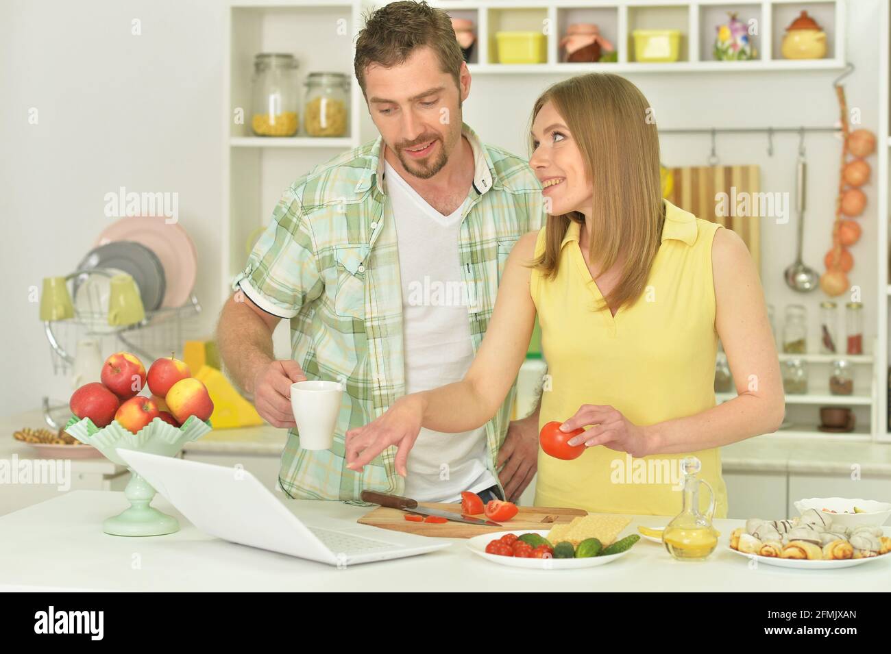 Happy husband and wife cooking together in the kitchen Stock Photo - Alamy
