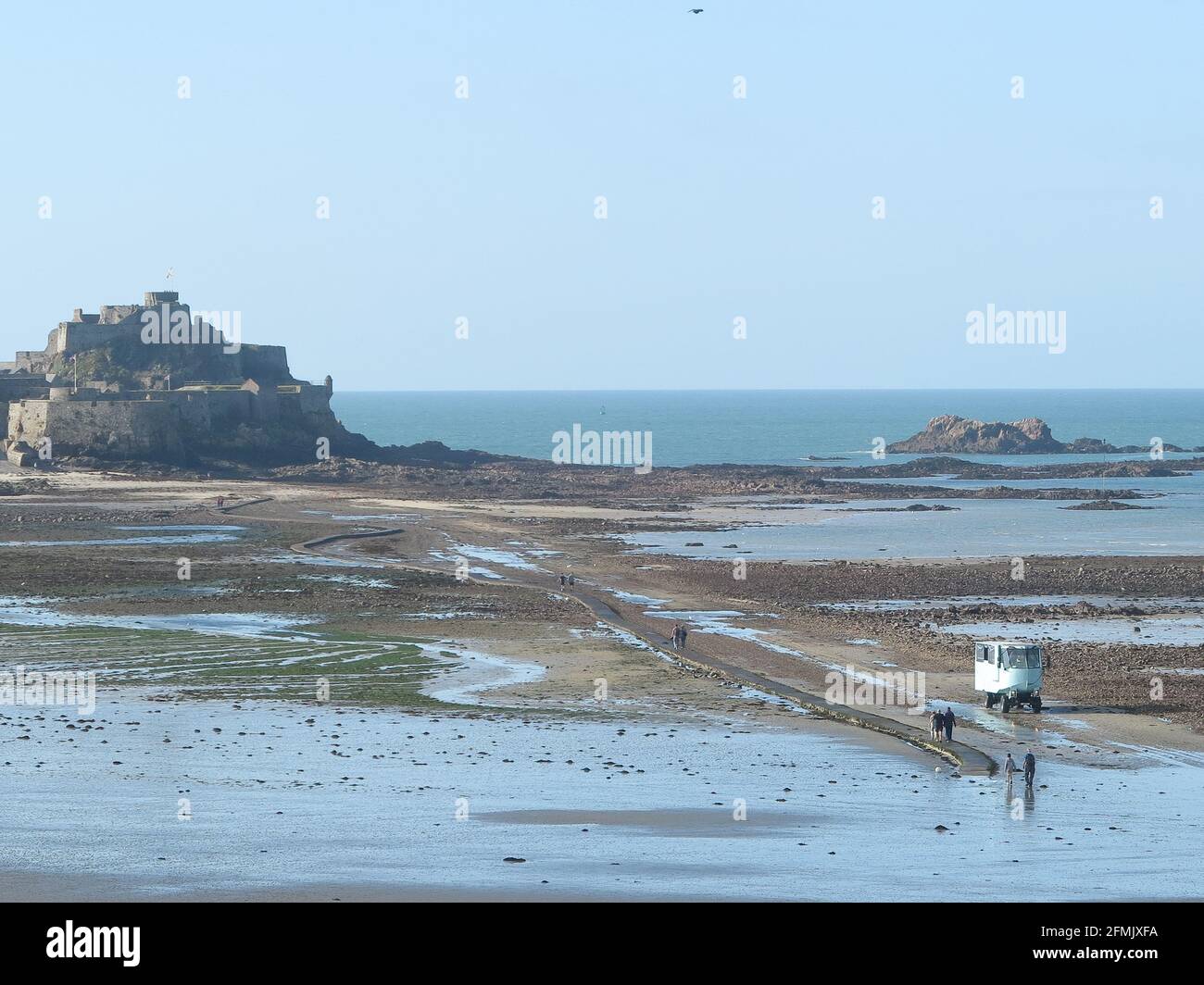 Elizabeth Castle at St. Aubin's Bay and low tide access causeway with ...